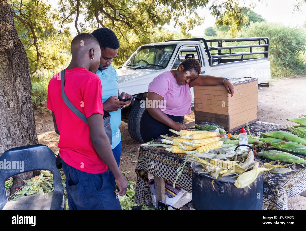 african street vendor selling boiled sweetcorn on the side of the road ...