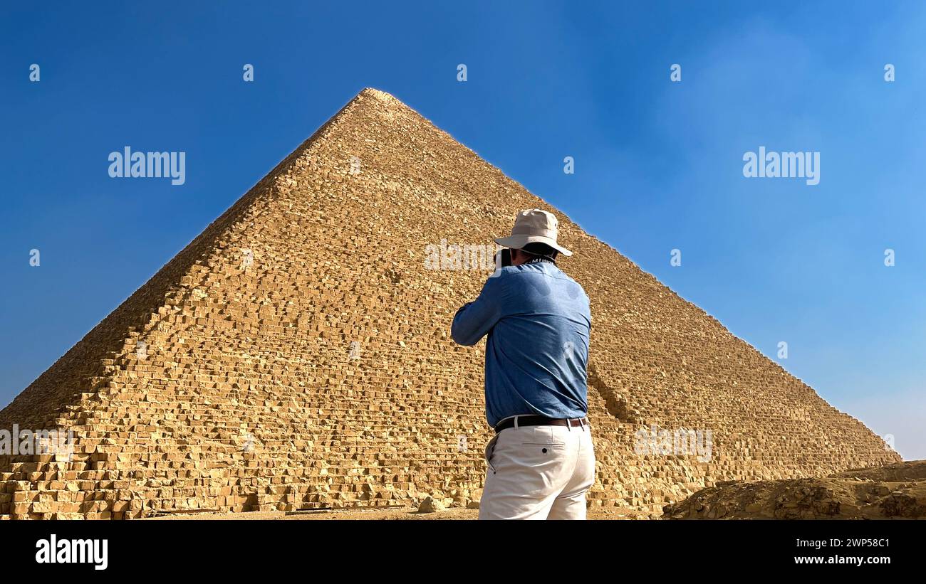 Tourist with hat photographing a pyramid in Egypt with his camera Stock ...
