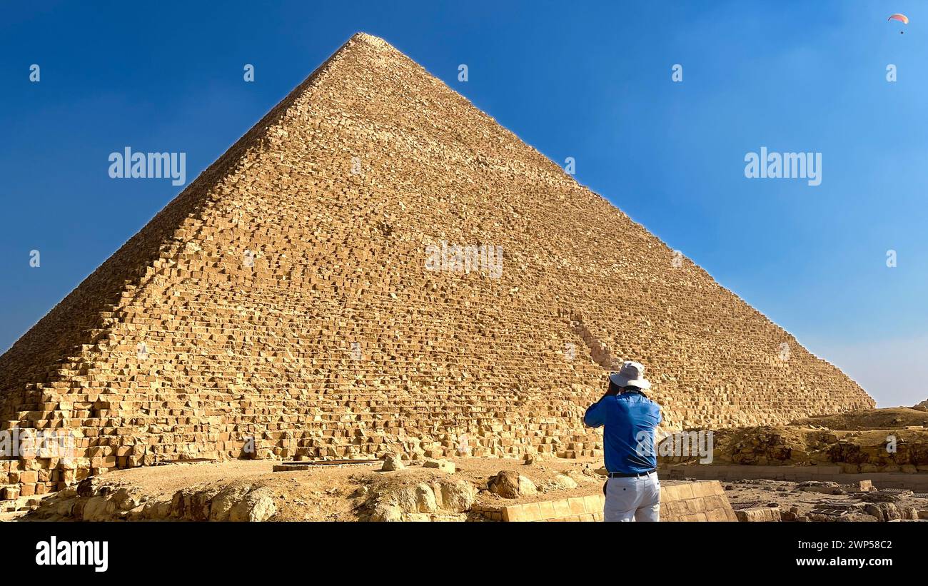 Tourist with hat photographing a pyramid in Egypt with his camera Stock ...