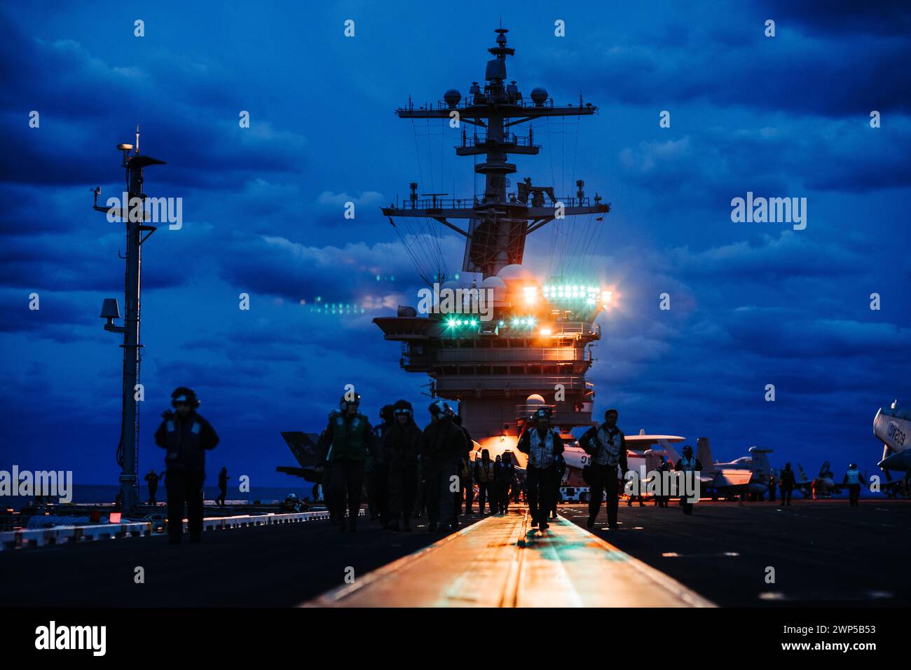 Sailors walk to the bow in preparation for a morning foreign object ...