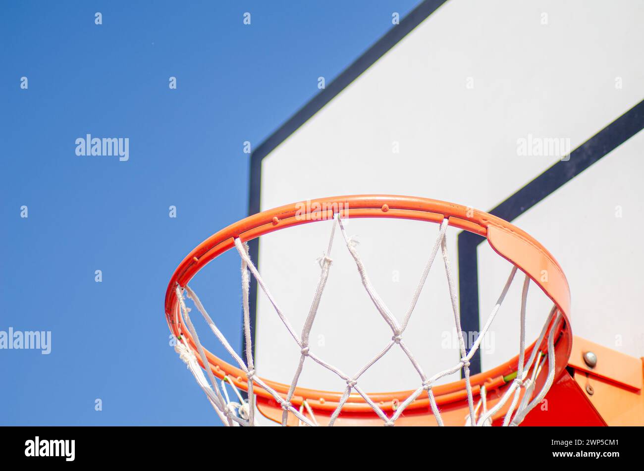 Close up of basketball hoop seen from below, blue sky background Stock ...