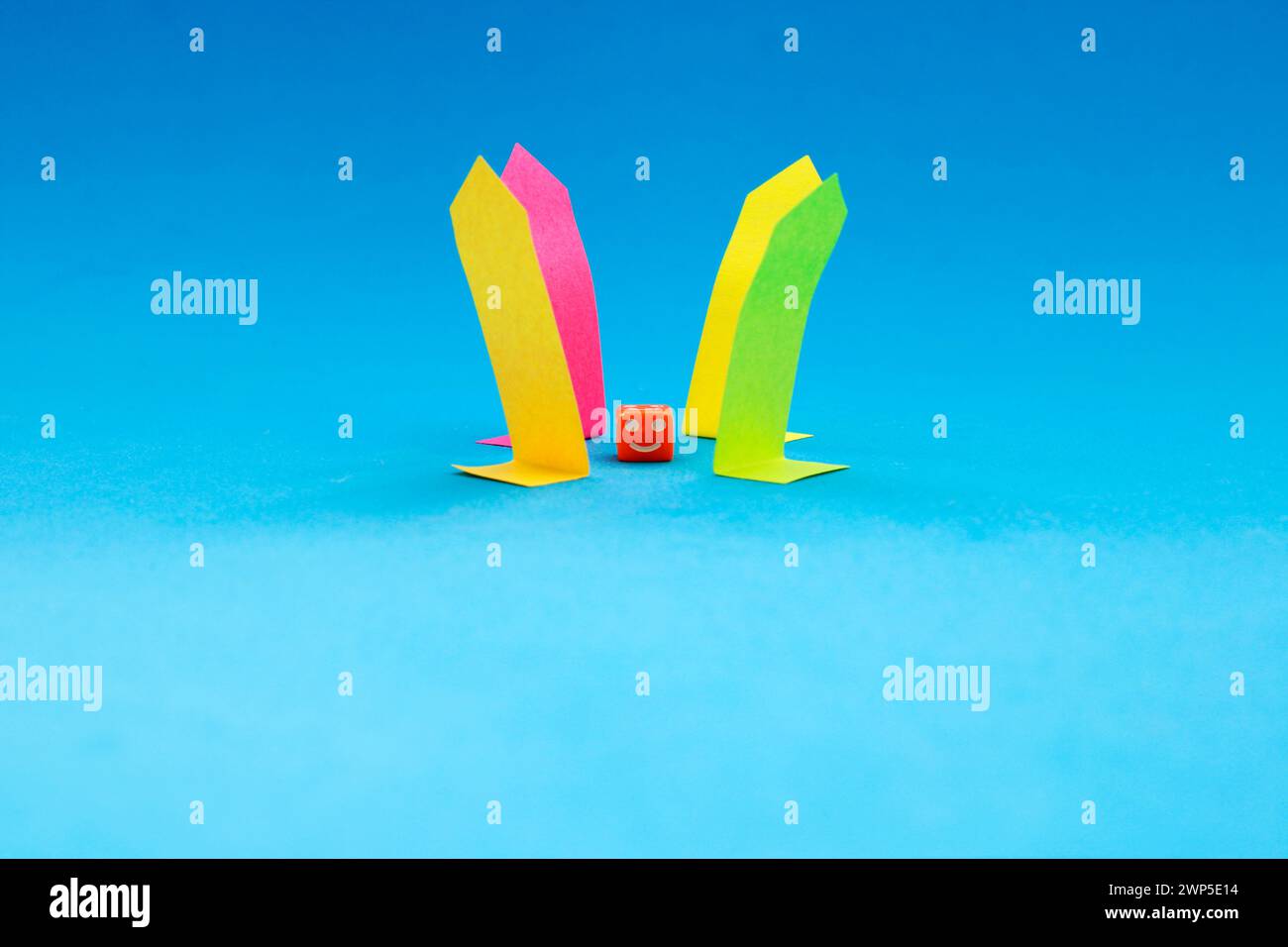 Cube with a happy face in the center of four notes that point upward ...