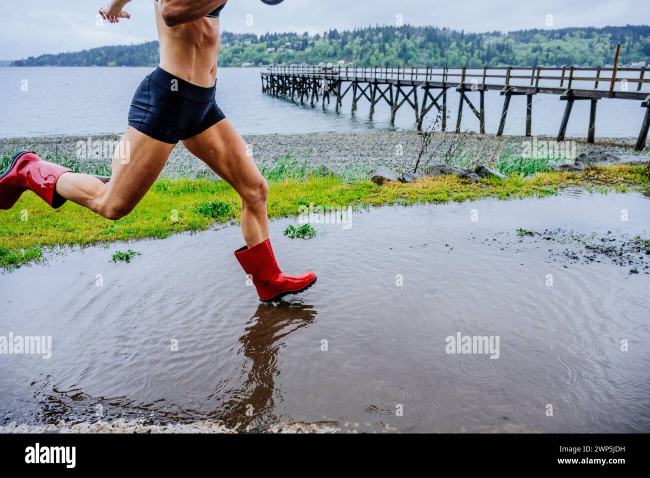 Female athlete running through puddle Stock Photo - Alamy