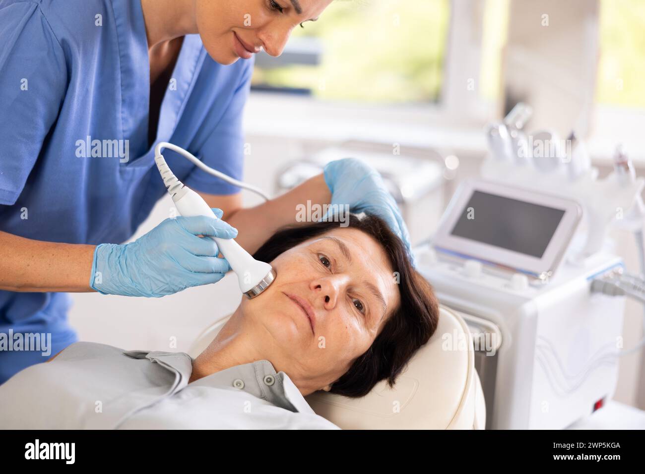 Aged woman receiving facial procedure with high frequency ultrasonic ... Aged woman receiving facial procedure with high frequency ultrasonic ...
