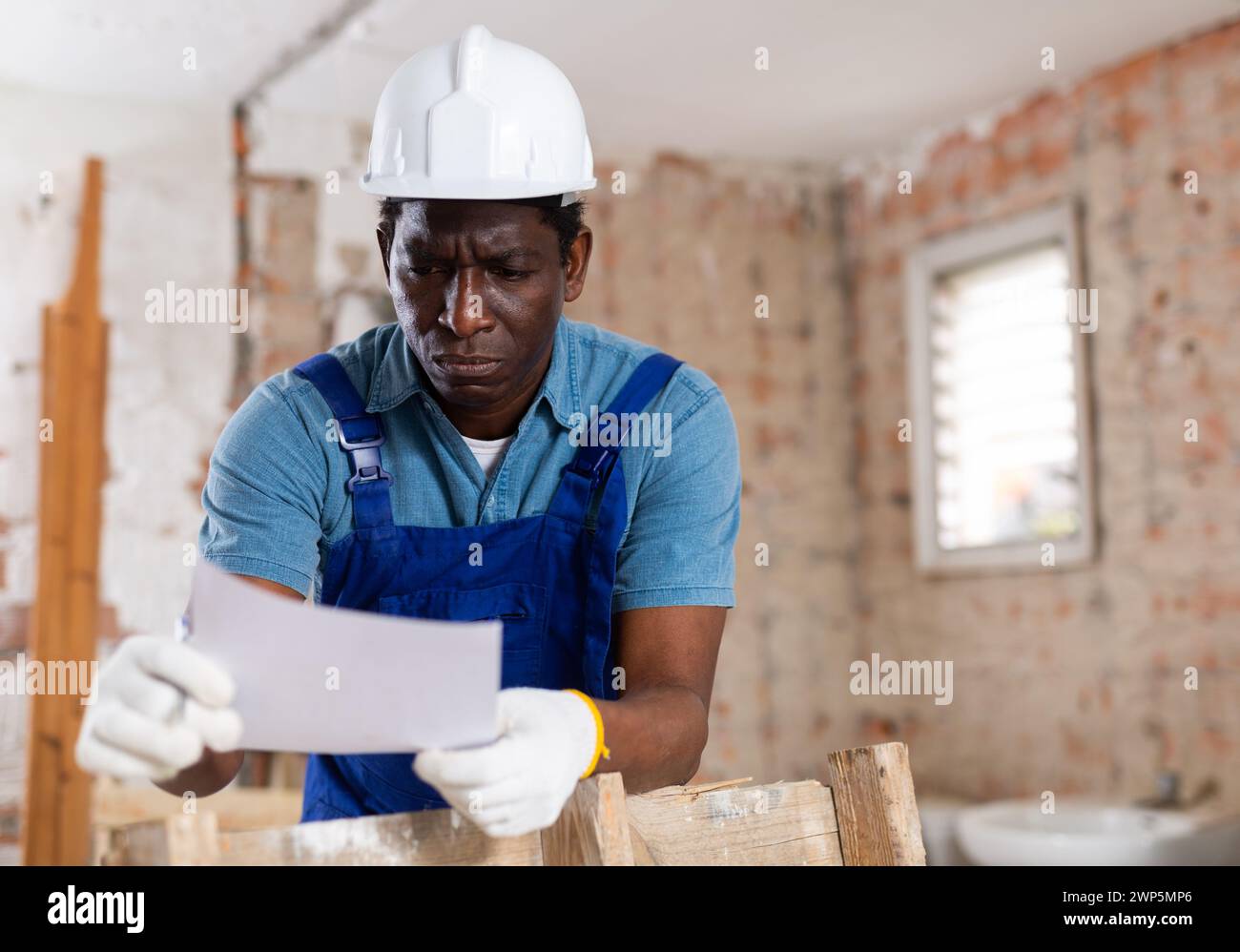Upset african american builder reading paper at construction site Stock ...