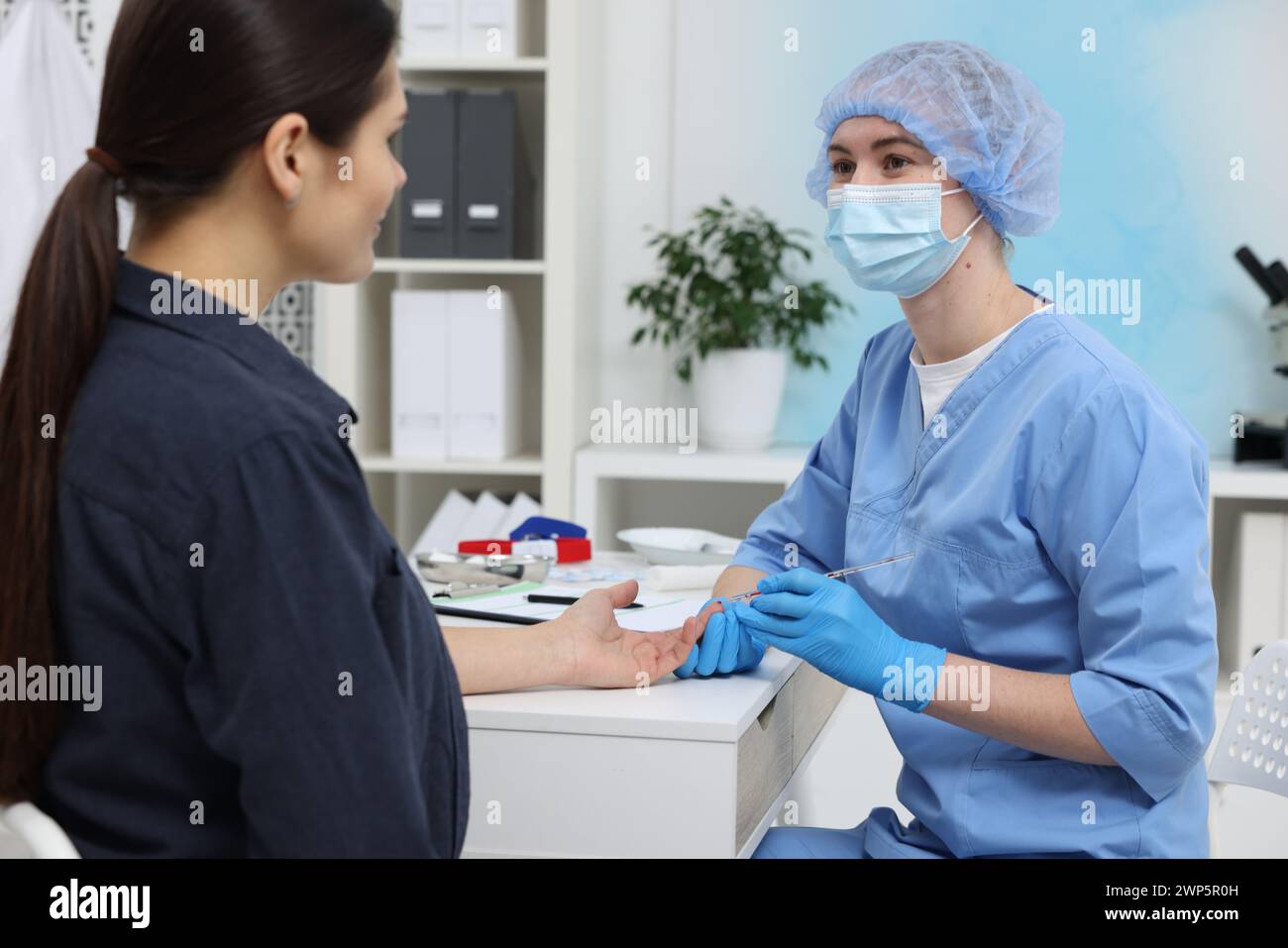 Laboratory testing. Doctor taking blood sample from patient at white ...