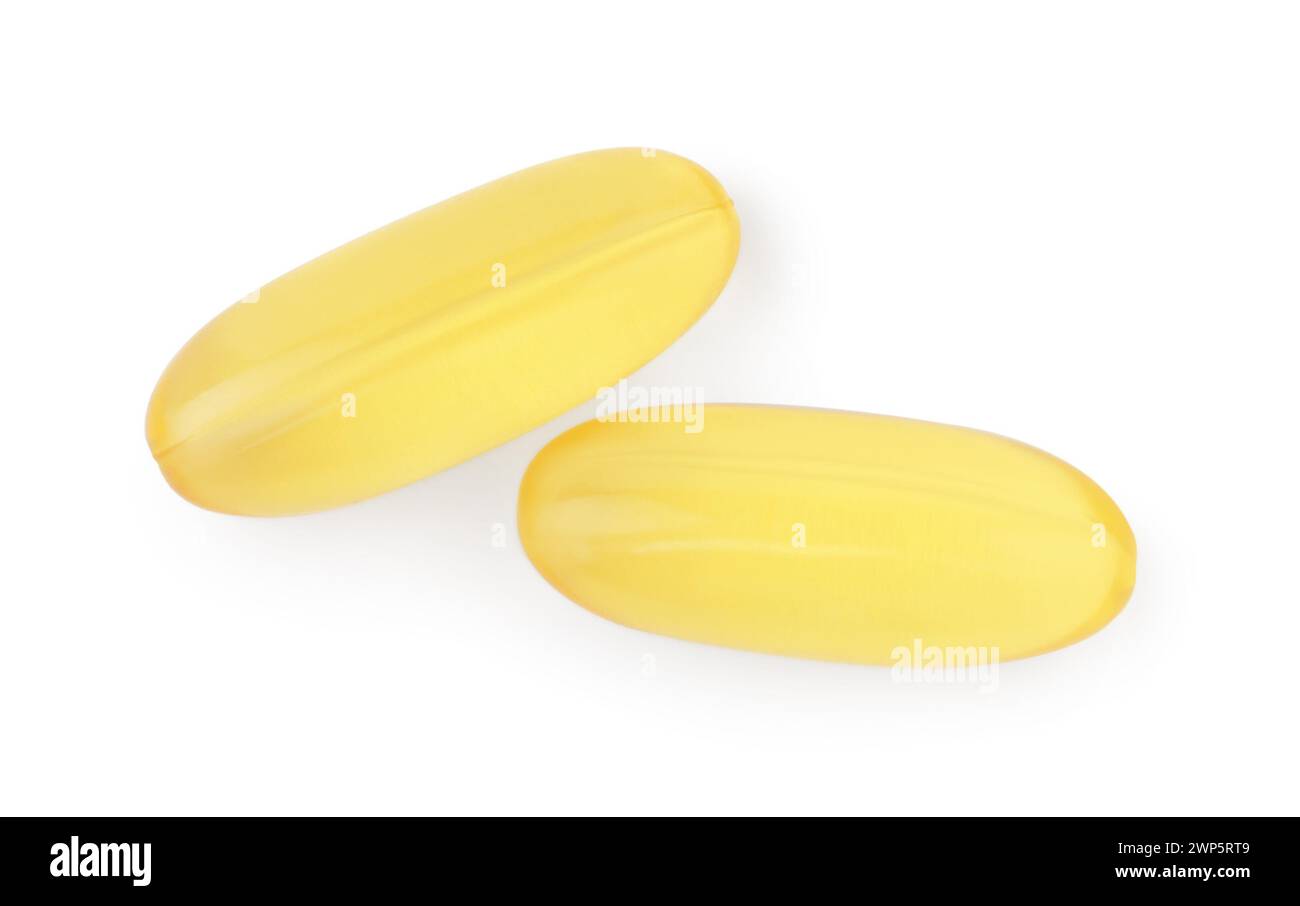 Yellow vitamin capsules isolated on white, top view Stock Photo - Alamy