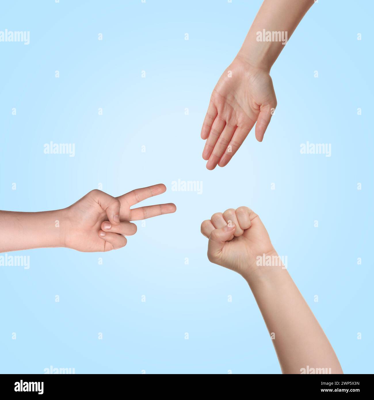 People playing rock, paper and scissors on light blue background, top ...