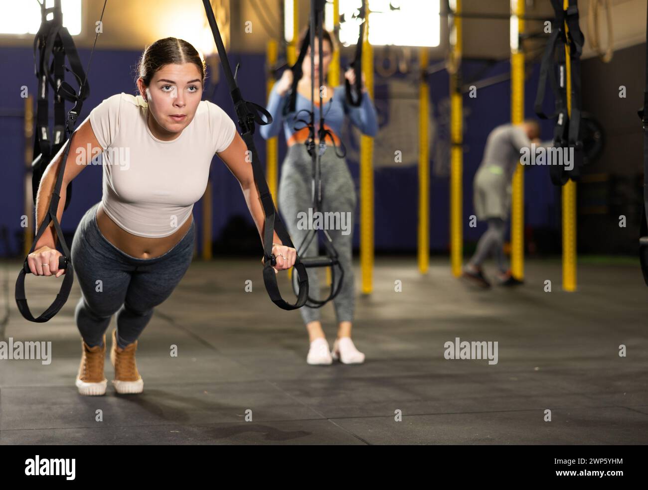 Active athlete young woman during exercises on crossover exercise ...