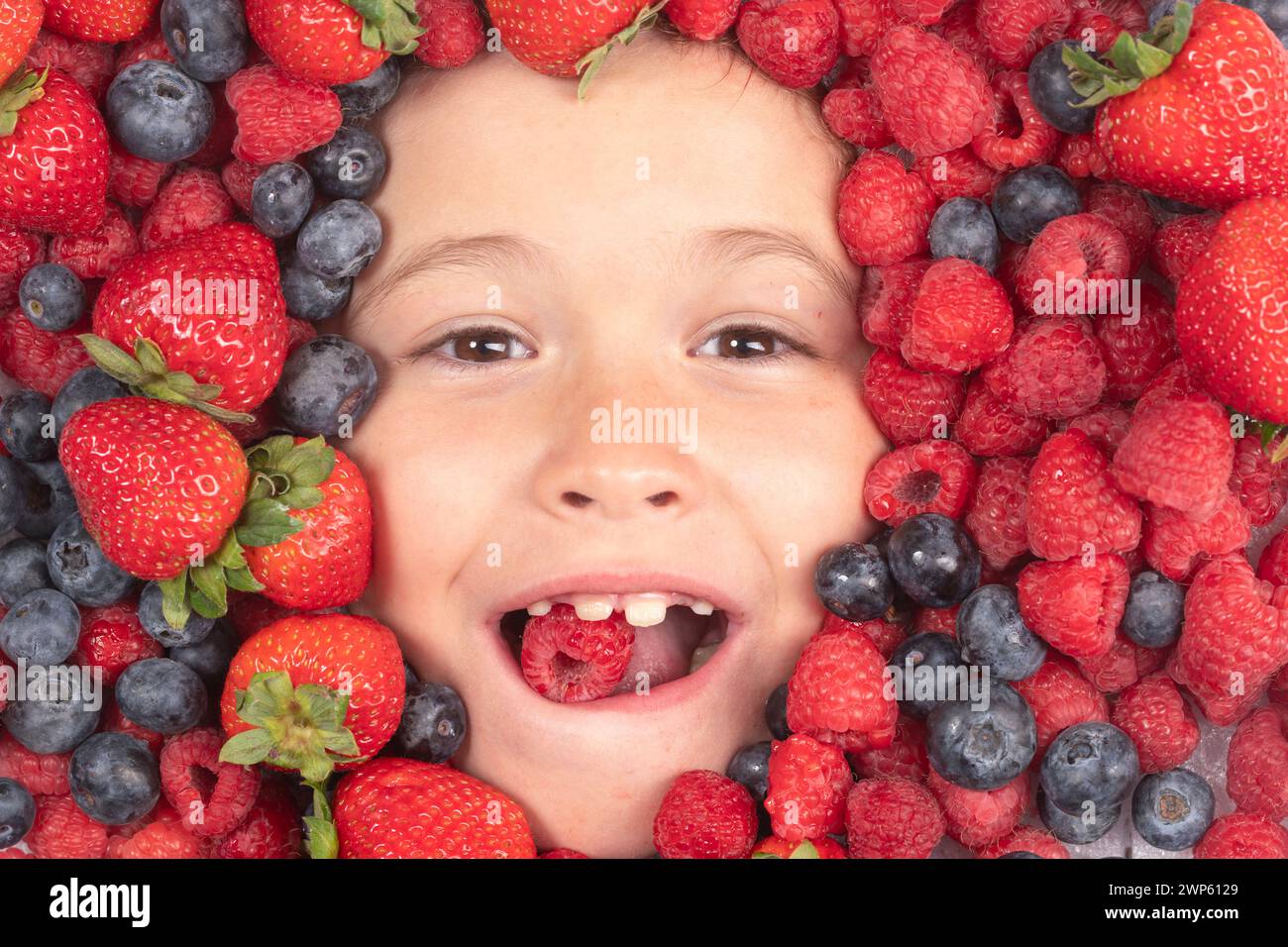 Summer fruits. Berries child face close up. Top view photo of child ...