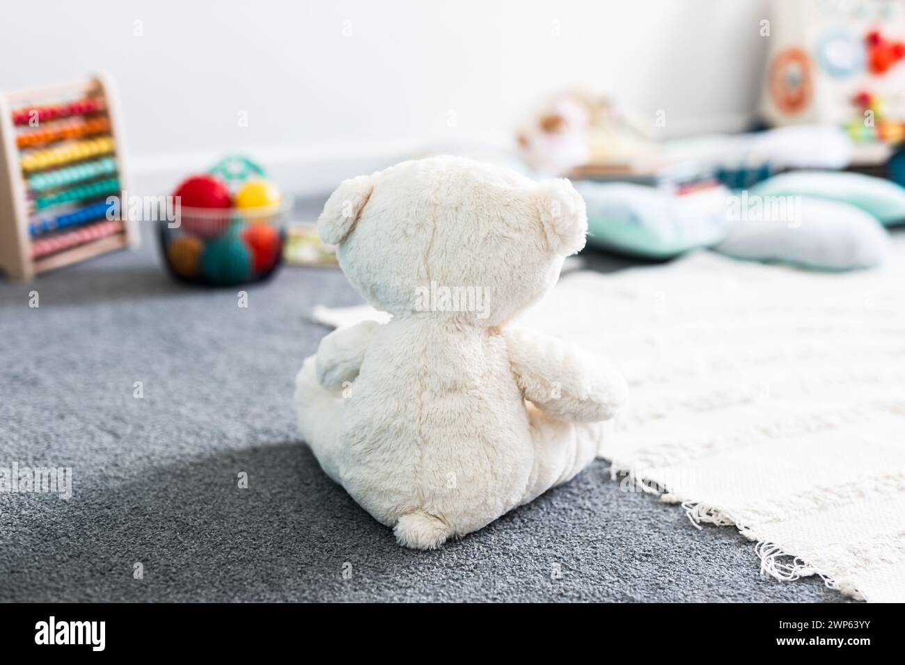 white teddy bear seen from behind in beautiful happy and messy nursery ...