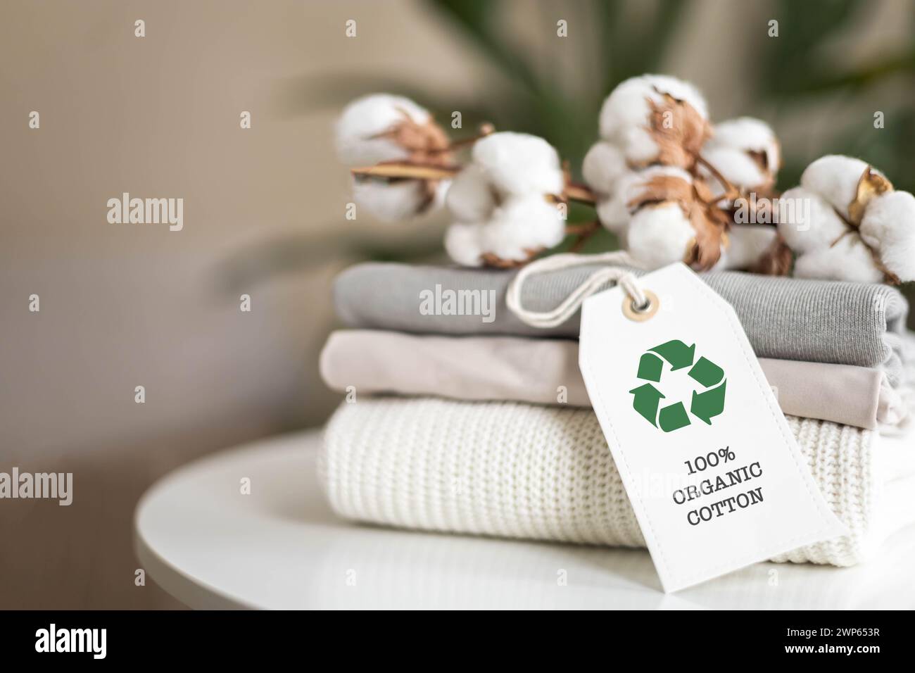 A neat stack of knitted clothing labeled 100% organic cotton Stock ...