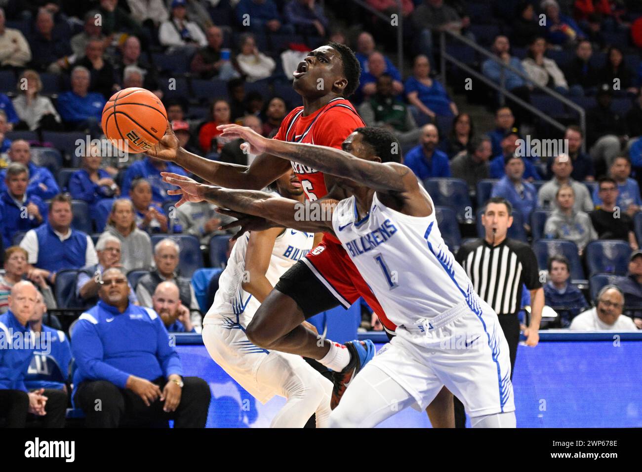 Dayton's Enoch Cheeks, center, goes up for a shot against Saint Louis ...