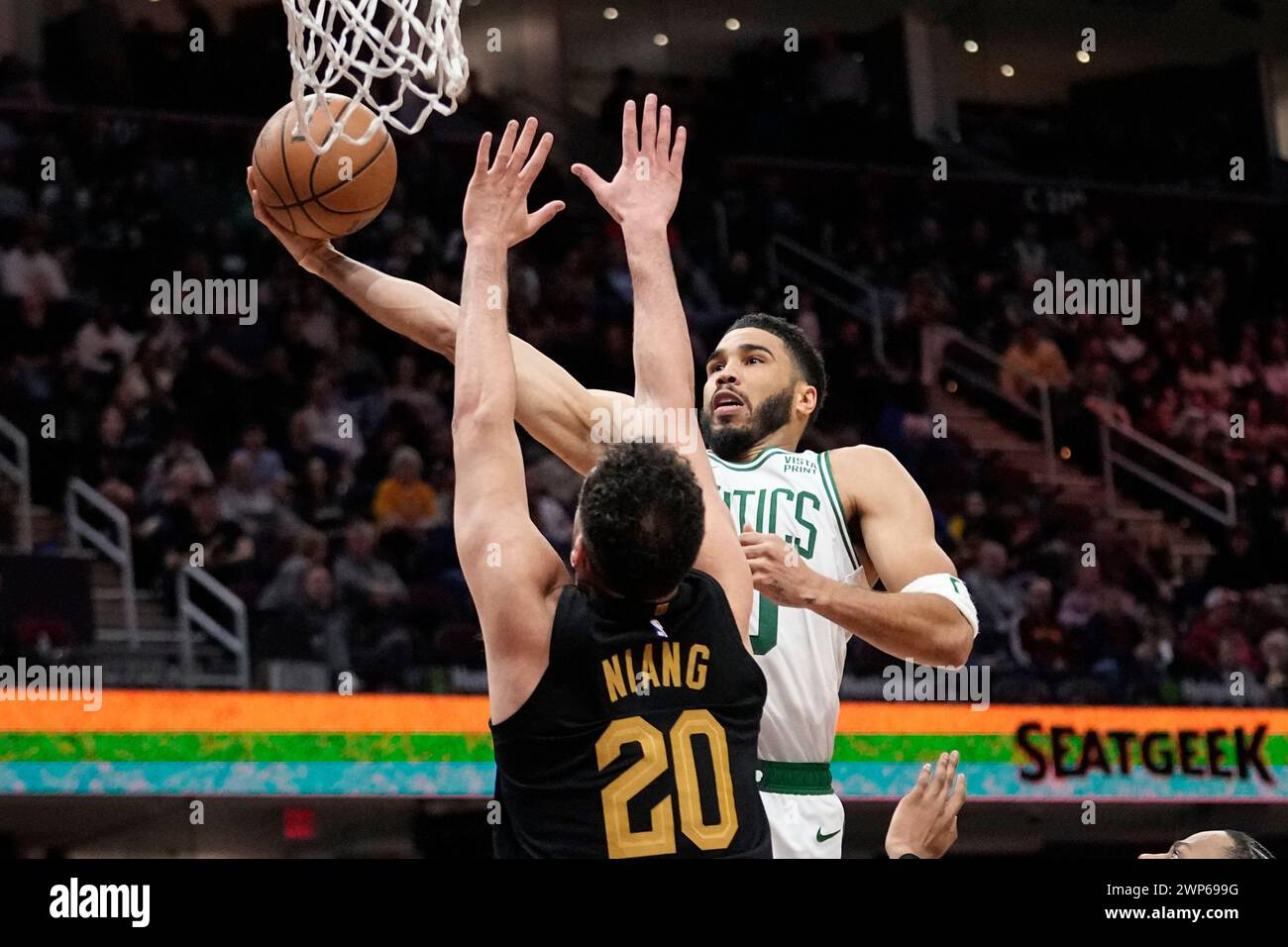 Boston Celtics forward Jayson Tatum, right, goes to the basket defended by Cleveland Cavaliers ...