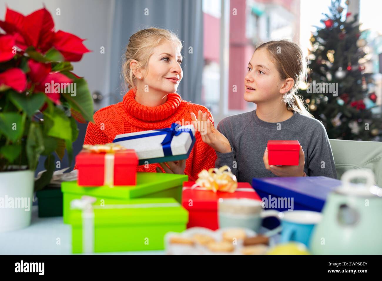 Mom and daughter unpack gifts during christmas Stock Photo - Alamy