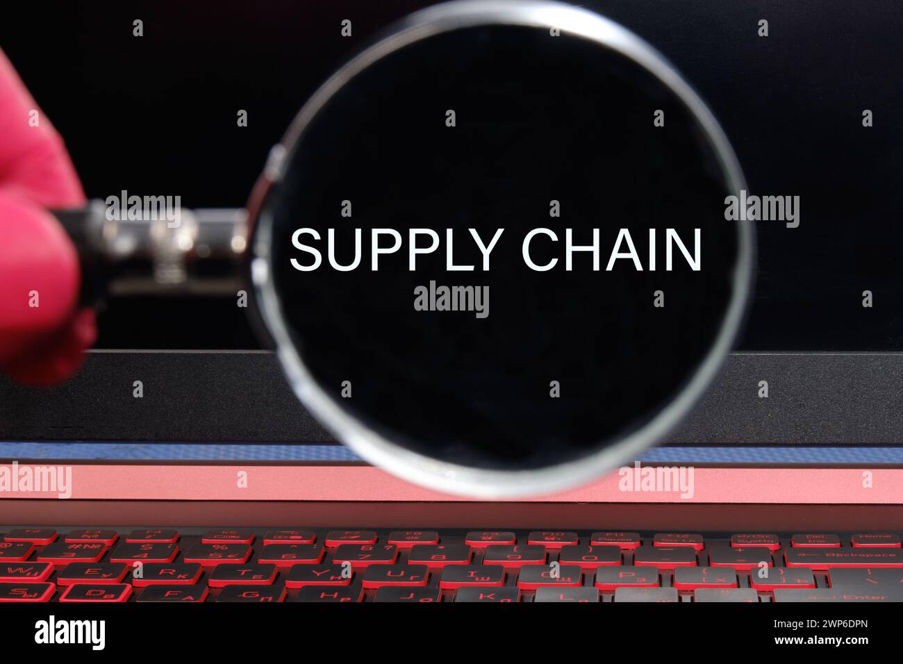 The words Supply Chain written through a magnifying glass on a black ...