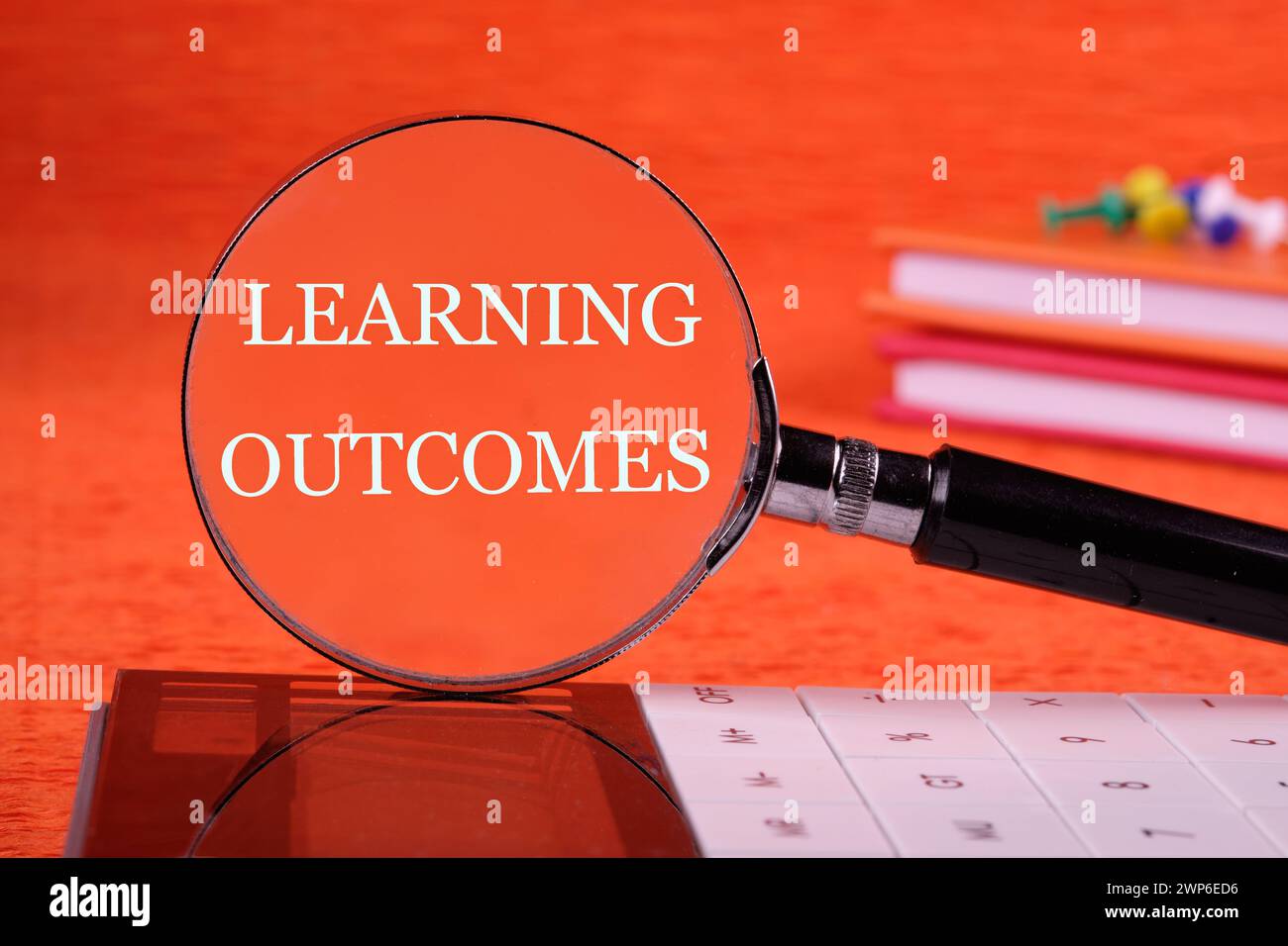 Learning Outcome write through a magnifying glass on an orange ...