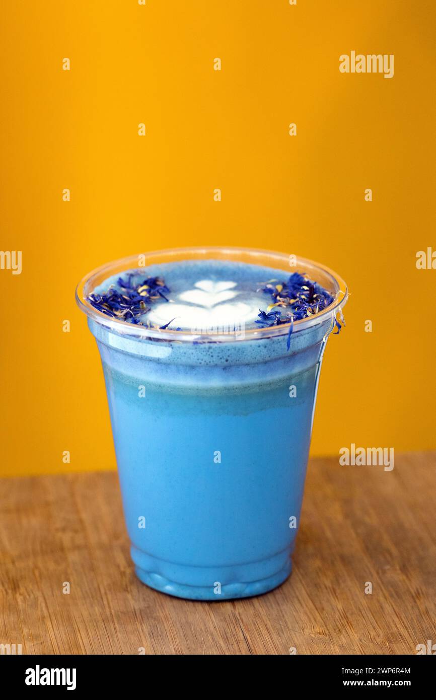 Glass of blue matcha tea, chasen and bowl on yellow background Stock ...