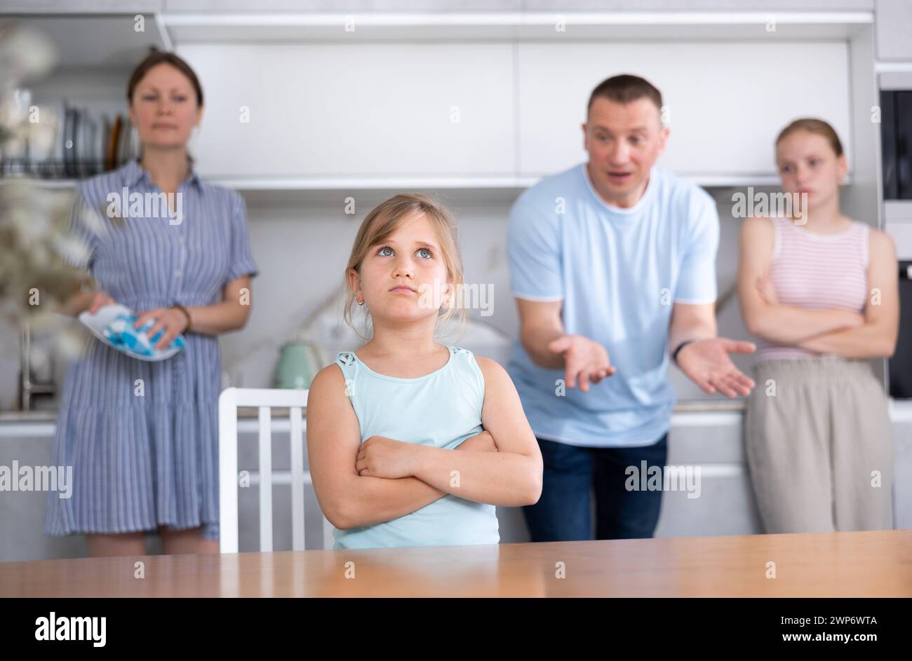 At kitchen parents scold standing daughter for bad behavior, mother ...