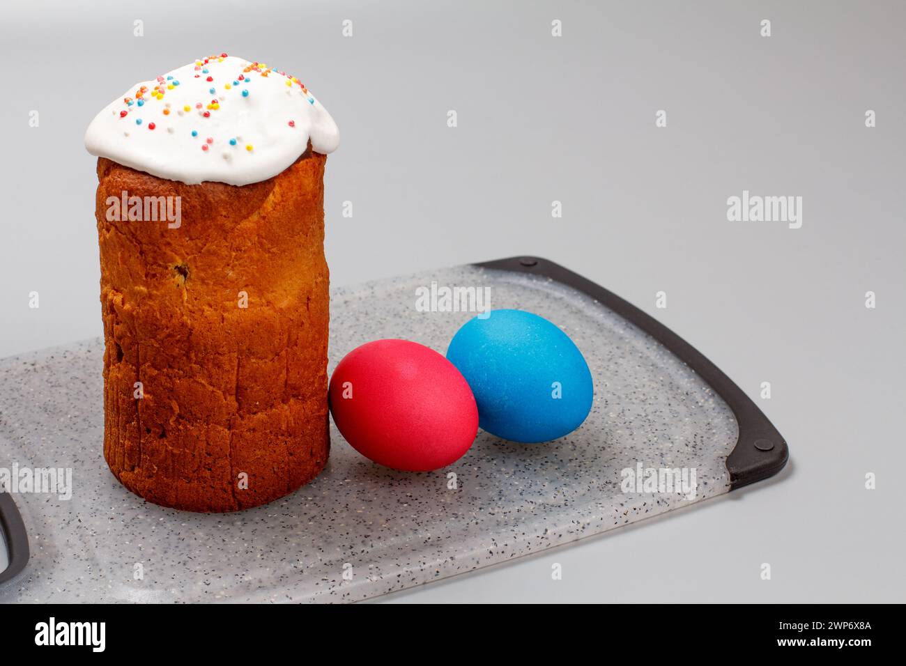 Easter cake and colorful Easter eggs on the cutting board. Traditional ...