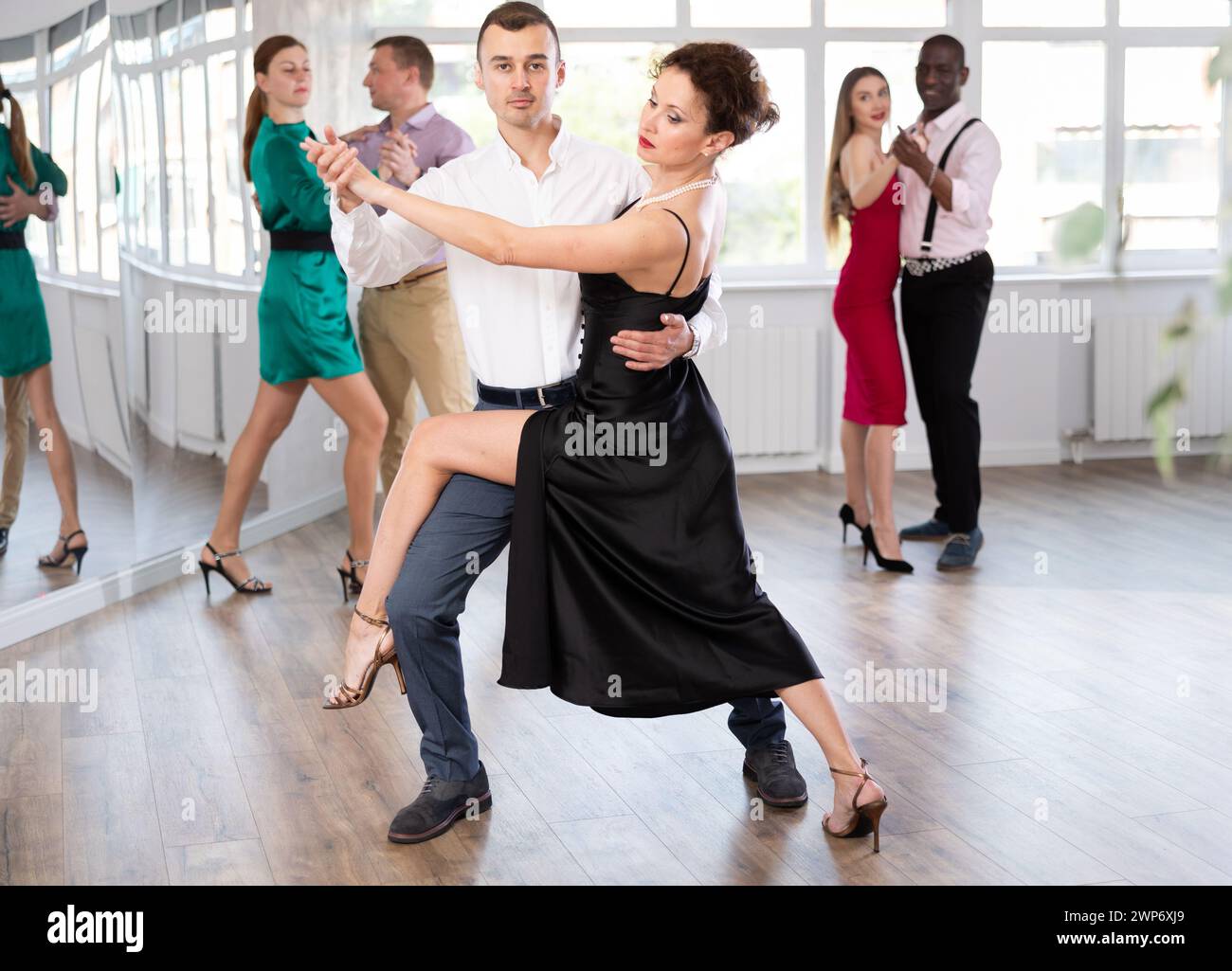 Elegant couple performs an expressive tango in bright, modern dance ...
