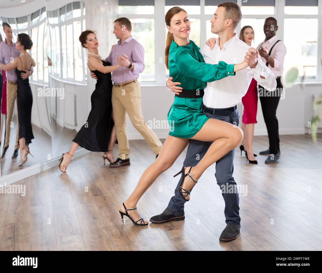 Elegant couple performs an expressive tango in bright, modern dance ...