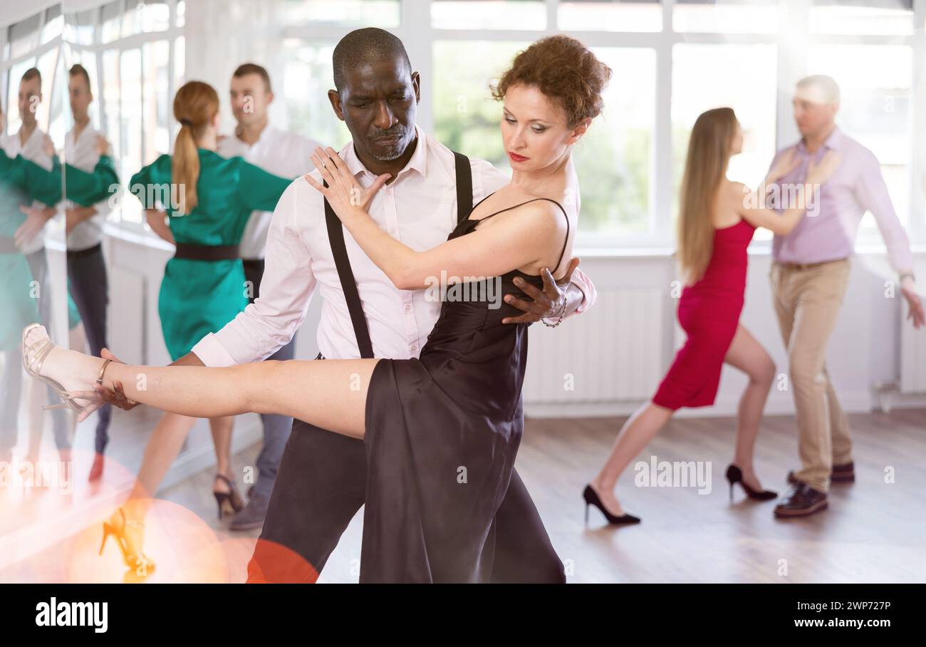 Elegant duet of man and woman in festive dresses dances passionate ...