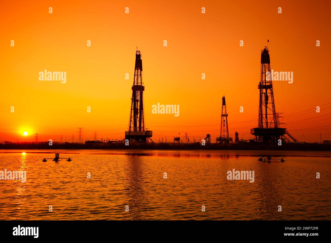 Sunset of oil drilling rig in the sea Stock Photo - Alamy