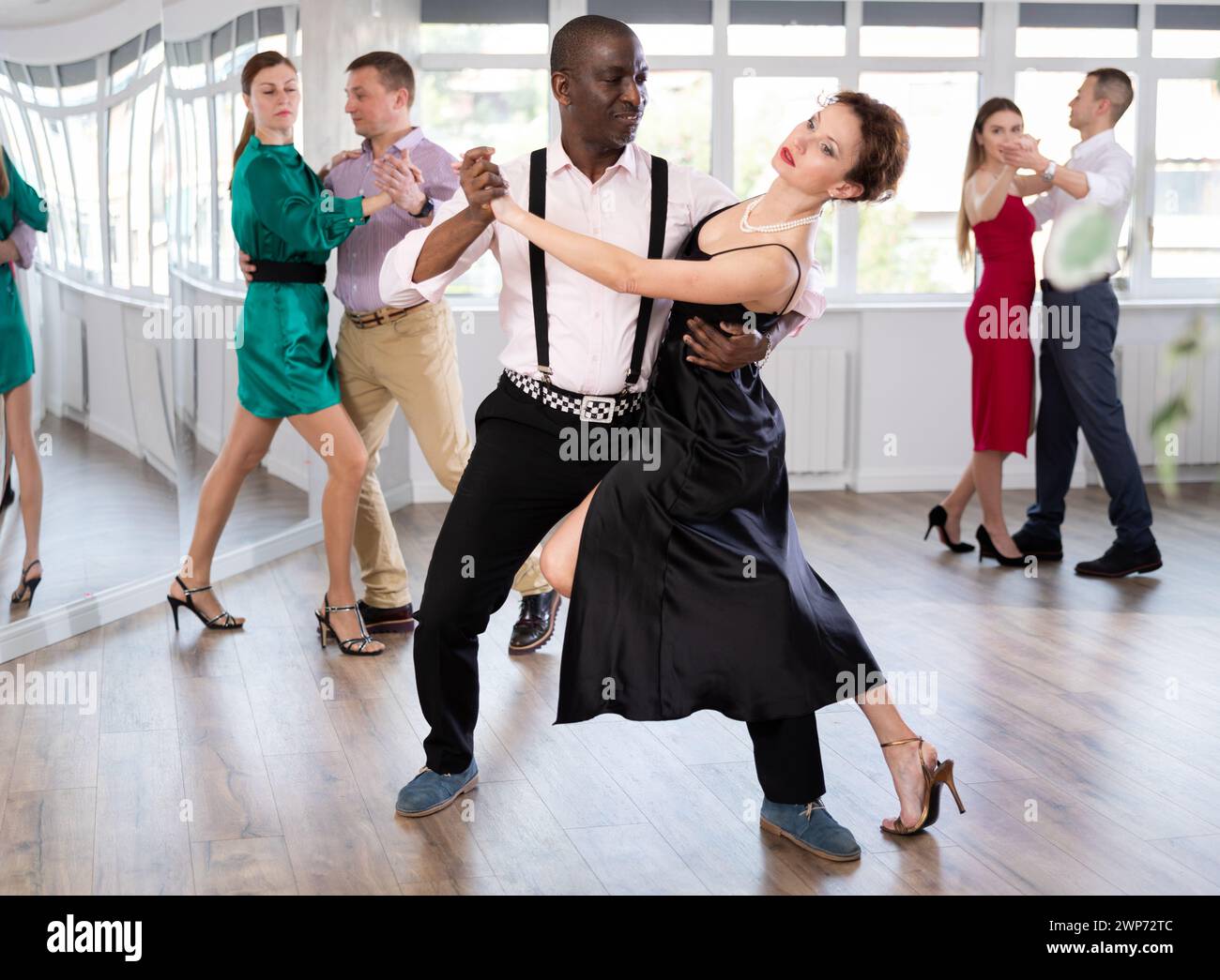Elegant couple performs an expressive tango in bright, modern dance ...