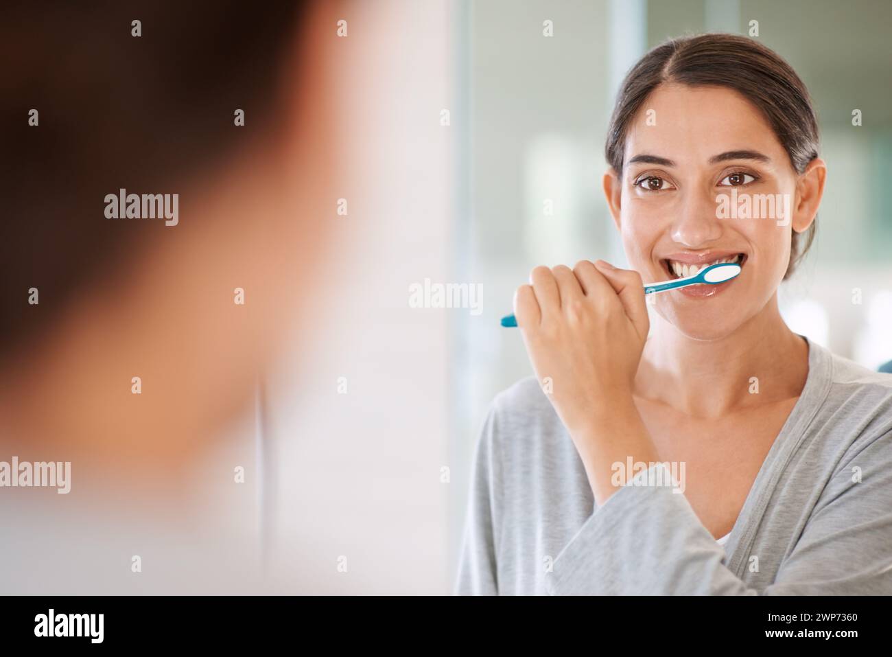 Woman, brushing teeth and smile in morning by mirror for health ...