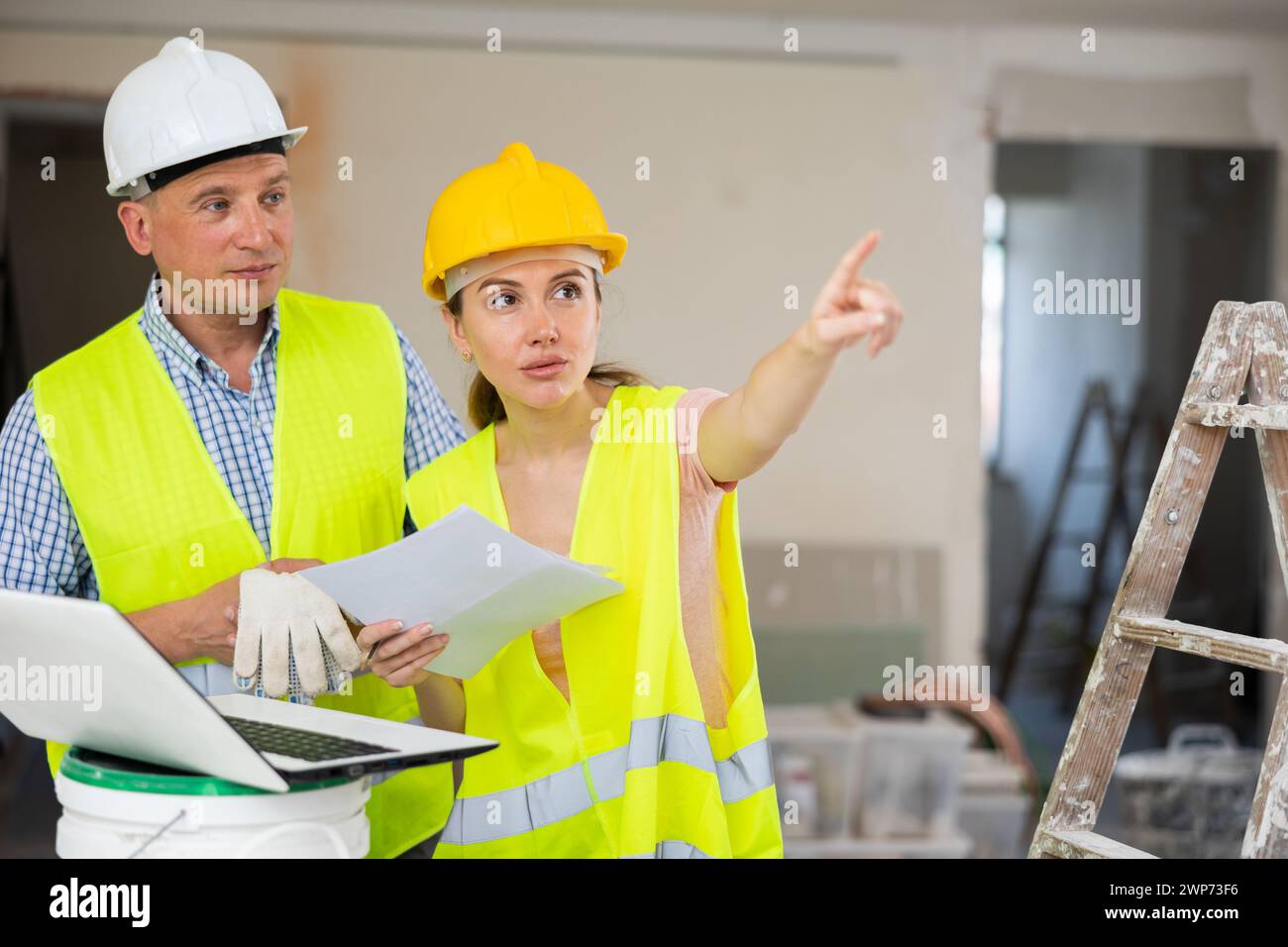 Man and woman builders talking in house Stock Photo - Alamy