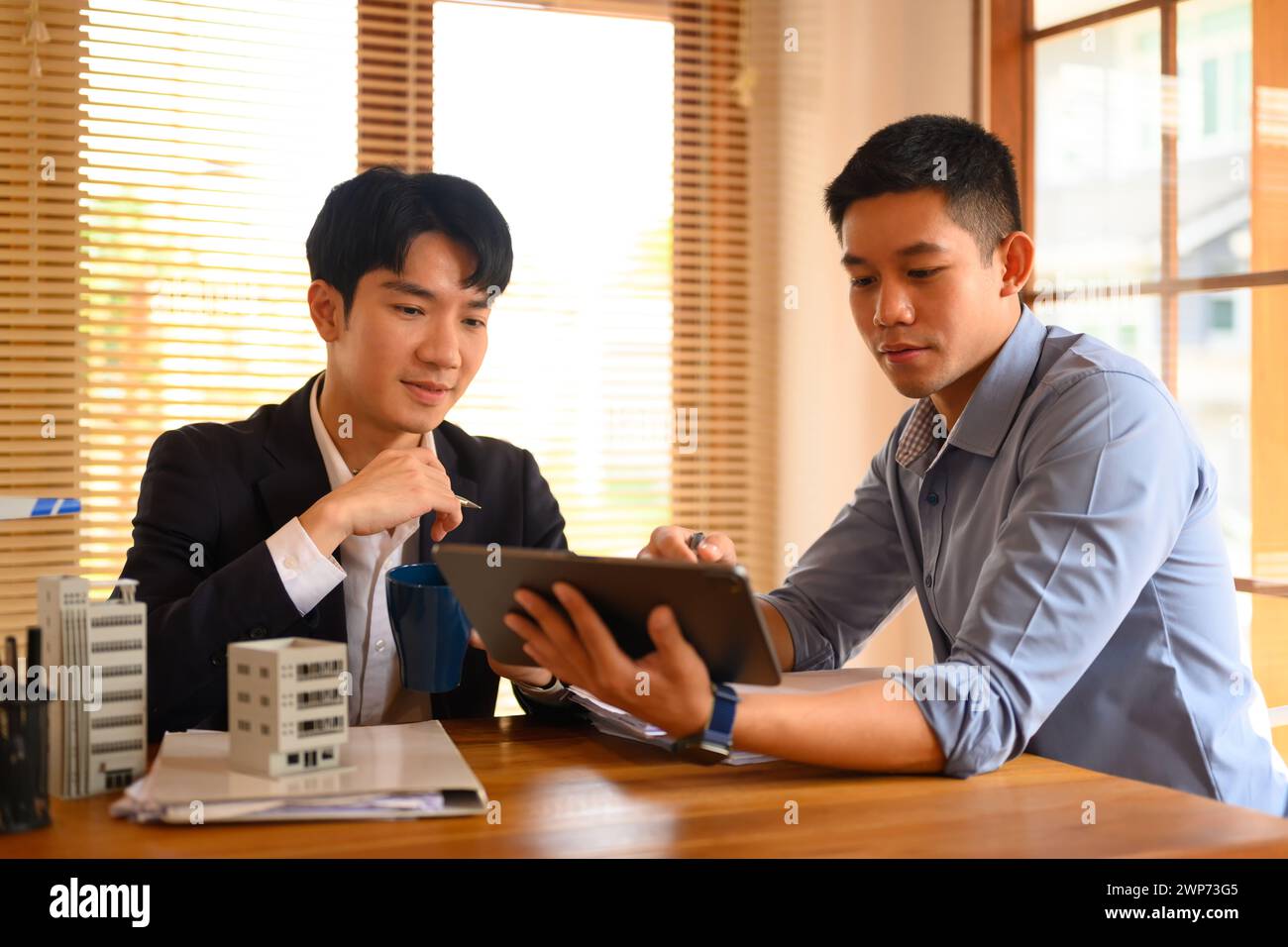 Architects men looking at digital tablet while working with ...