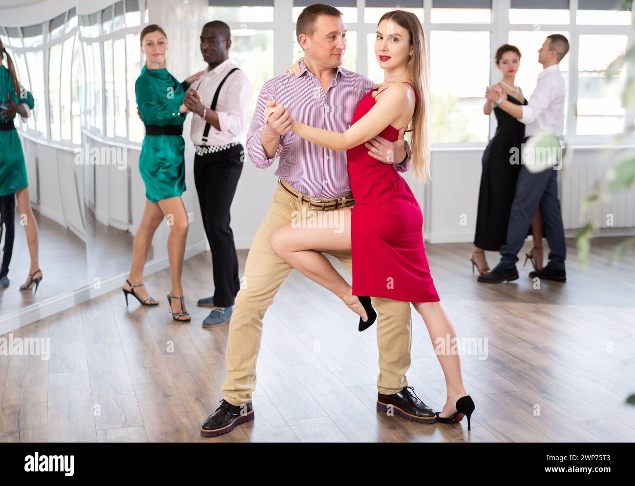 Elegant couple performs an expressive tango in bright, modern dance ...