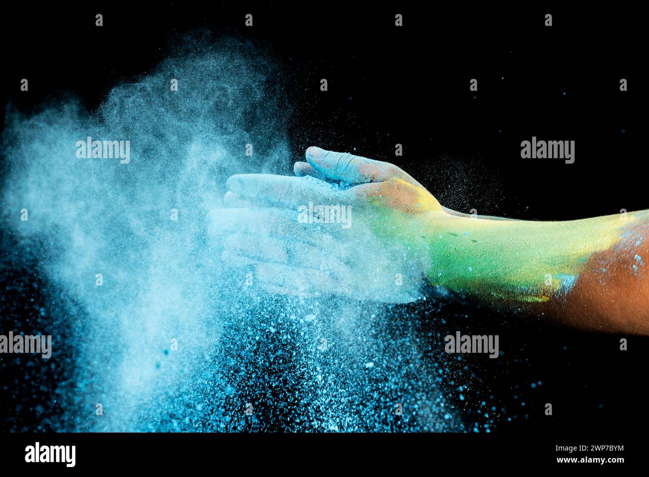 Human hand with colorful Holi powder on a black background. Holi ...
