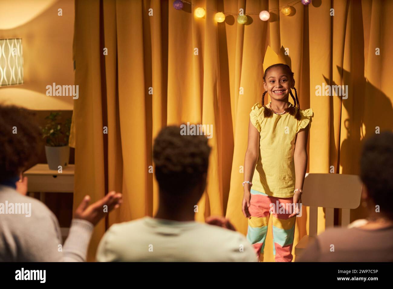 Portrait of smiling Black little girl standing on stage in makeshift ...