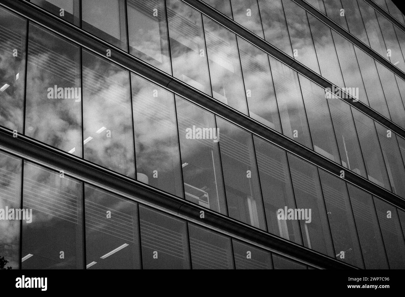 Modern office building glass facade, sky reflection in windows ...