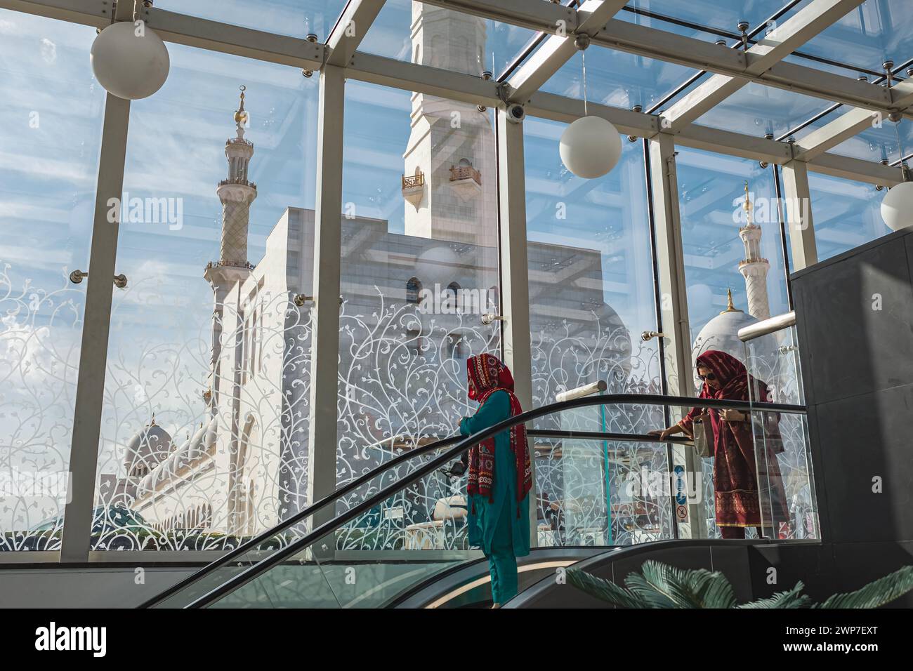 Women on escalator Abu Dhabi UAE. Traditionally dressed women in ...
