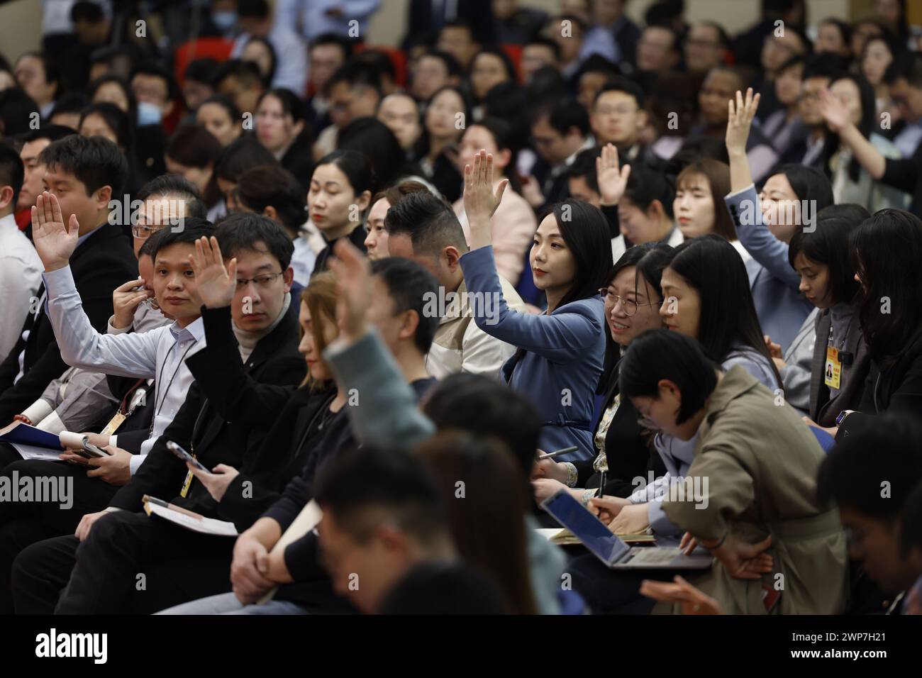 Beijing, China. 6th Mar, 2024. Journalists raise hands to ask questions ...