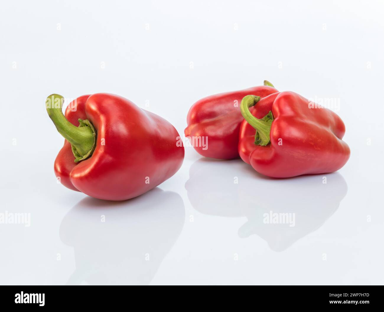 Three red bell peppers (paprika, capsicum) isolated on white background ...