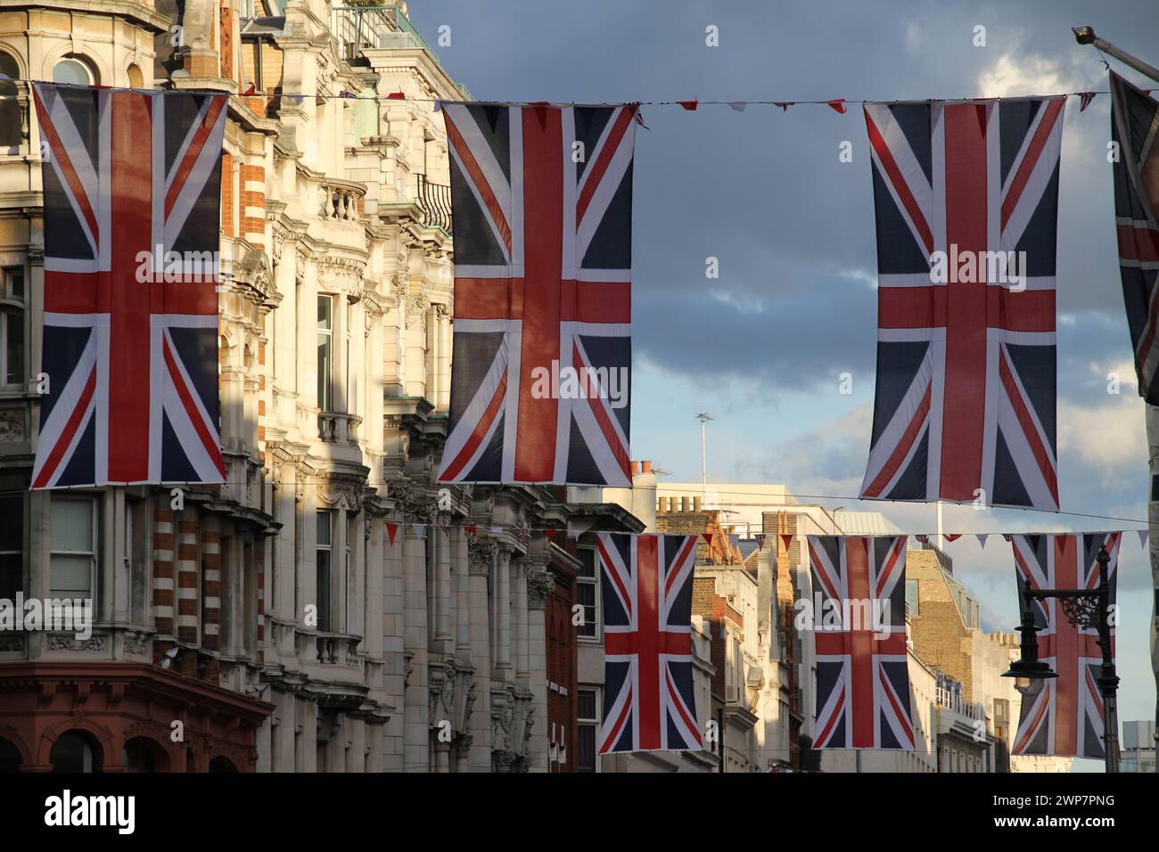 Some Union Jack flags in London waving on a building in sunlight Stock ...