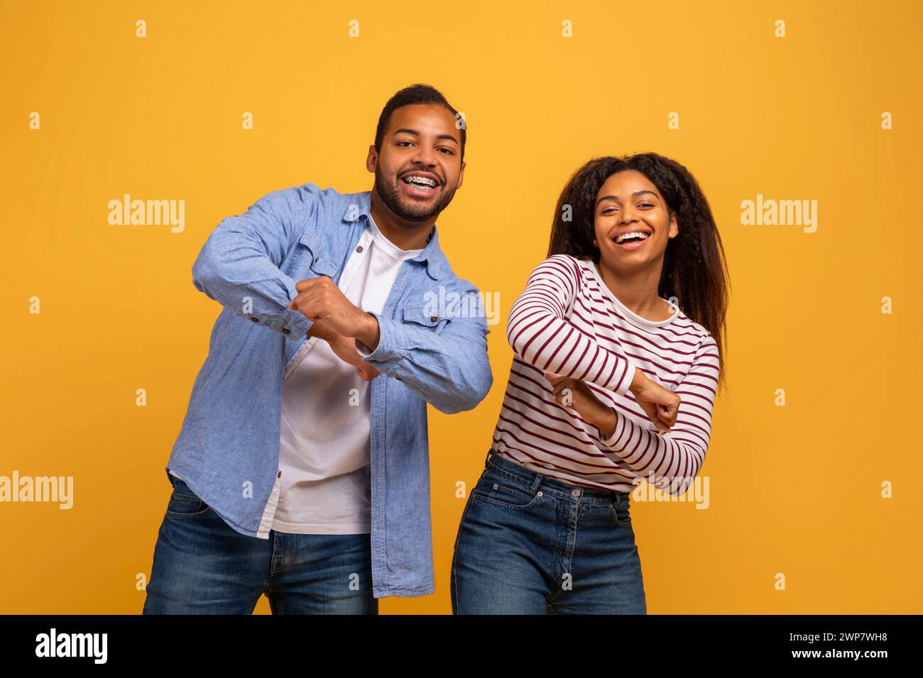 Carefree Young Black Couple Dancing Together Against Yellow Studio ...