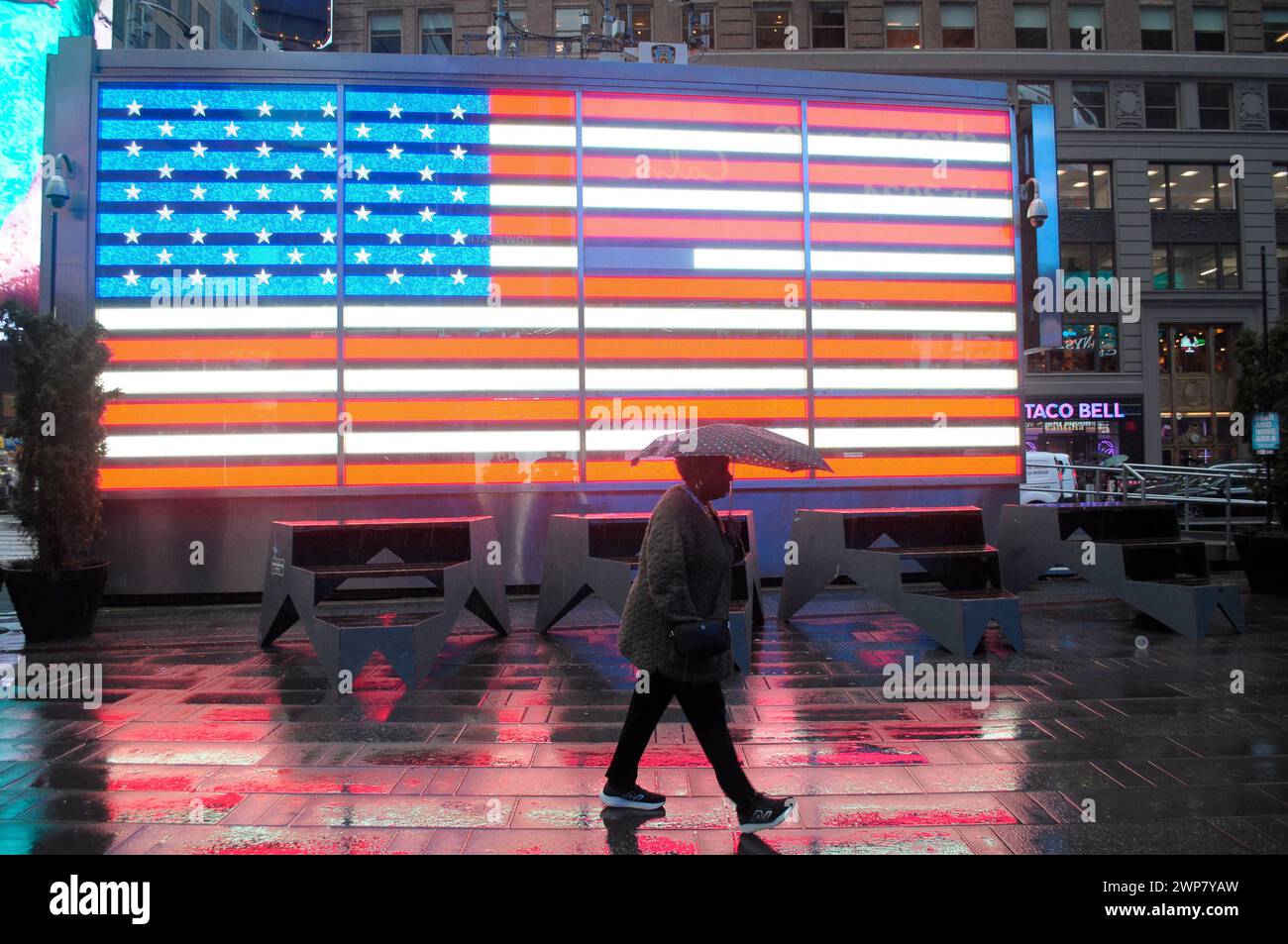 A pedestrian walks past a lighting installation of the American flag in ...