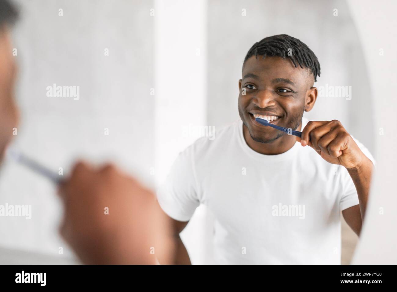 Handsome African American millennial guy brushing teeth in modern bathroom Stock Photo - Alamy
