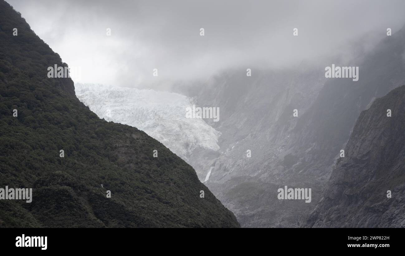Massive glacier flowing into a valley through steep rock walls shot in ...