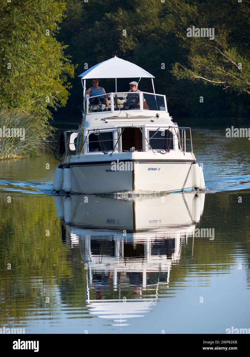 A mid-summer scene of tranquil beauty on the Thames as a houseboat ...