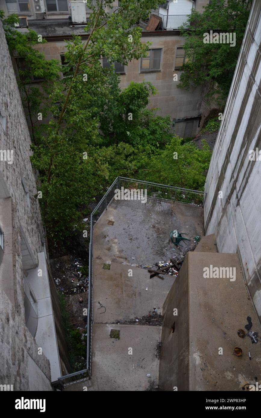 A balcony with a railing overlooking a yard cluttered with garbage ...