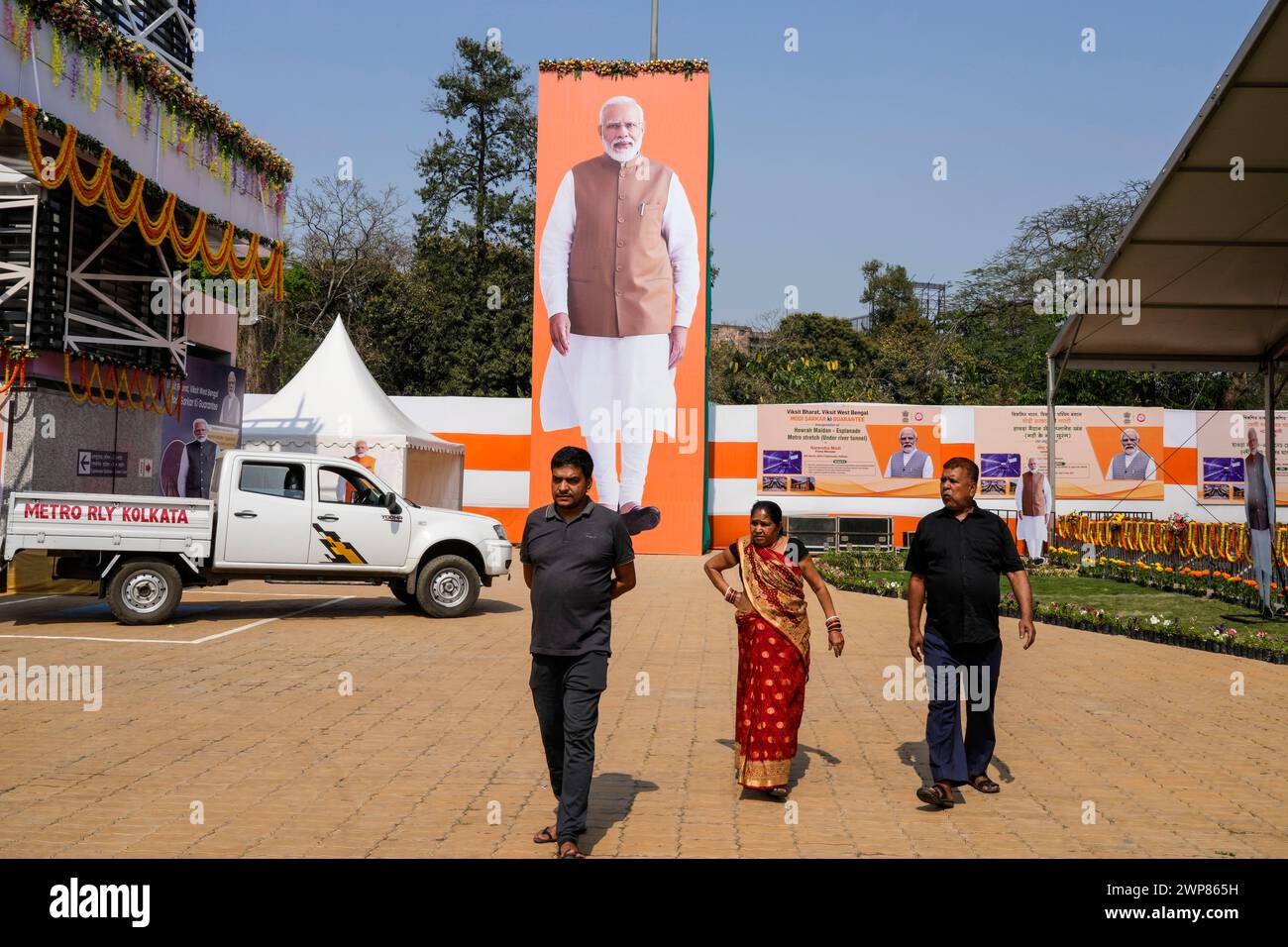 People walk next to a huge poster of Prime Minister Narendra Modi ...