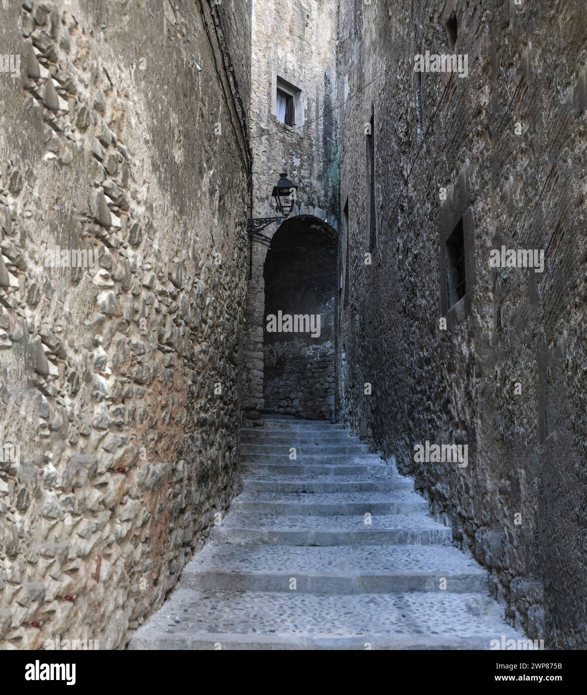 A scenic view of stone steps leading up to an arch in a narrow alleyway ...