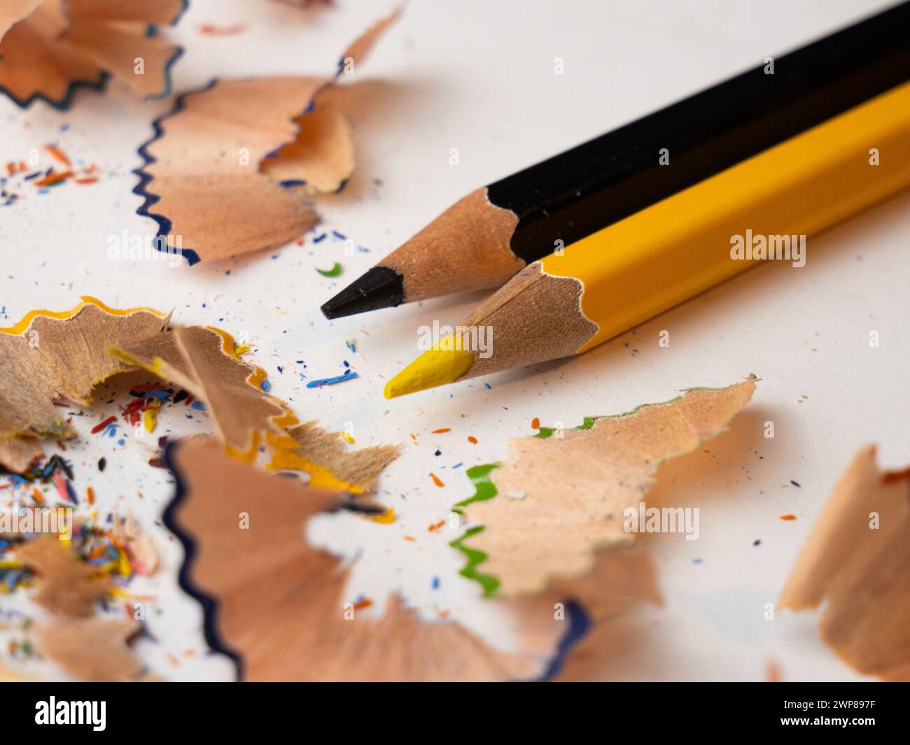 A close-up of assorted colorful pencils arranged on a white table ...