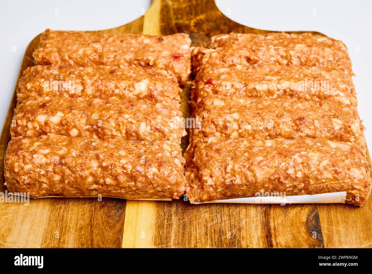 Meat rolls called (small) on a wooden counter, before being cooked ...